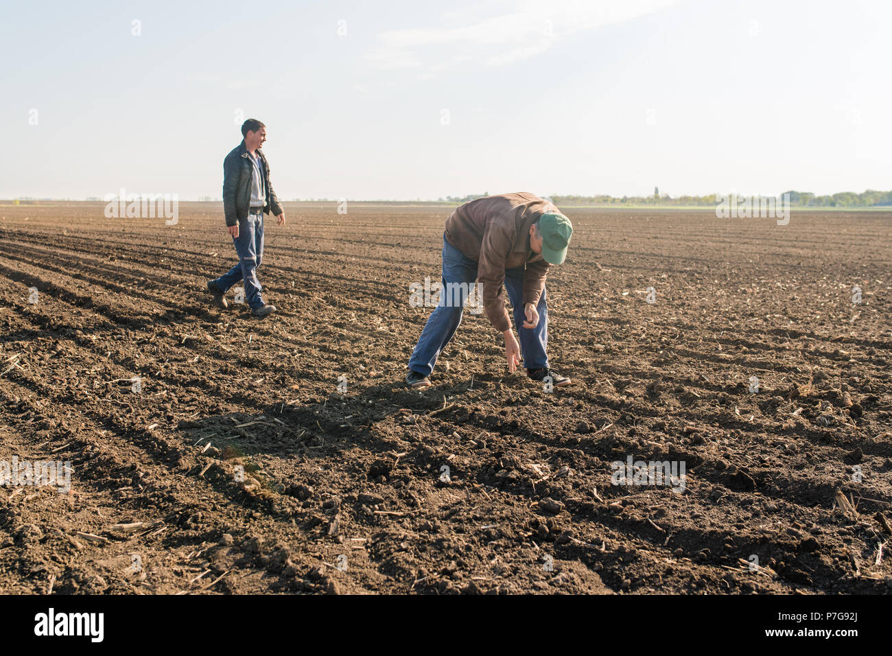 Farmers analyze soya seed after sowing crops at agricultural field in ...