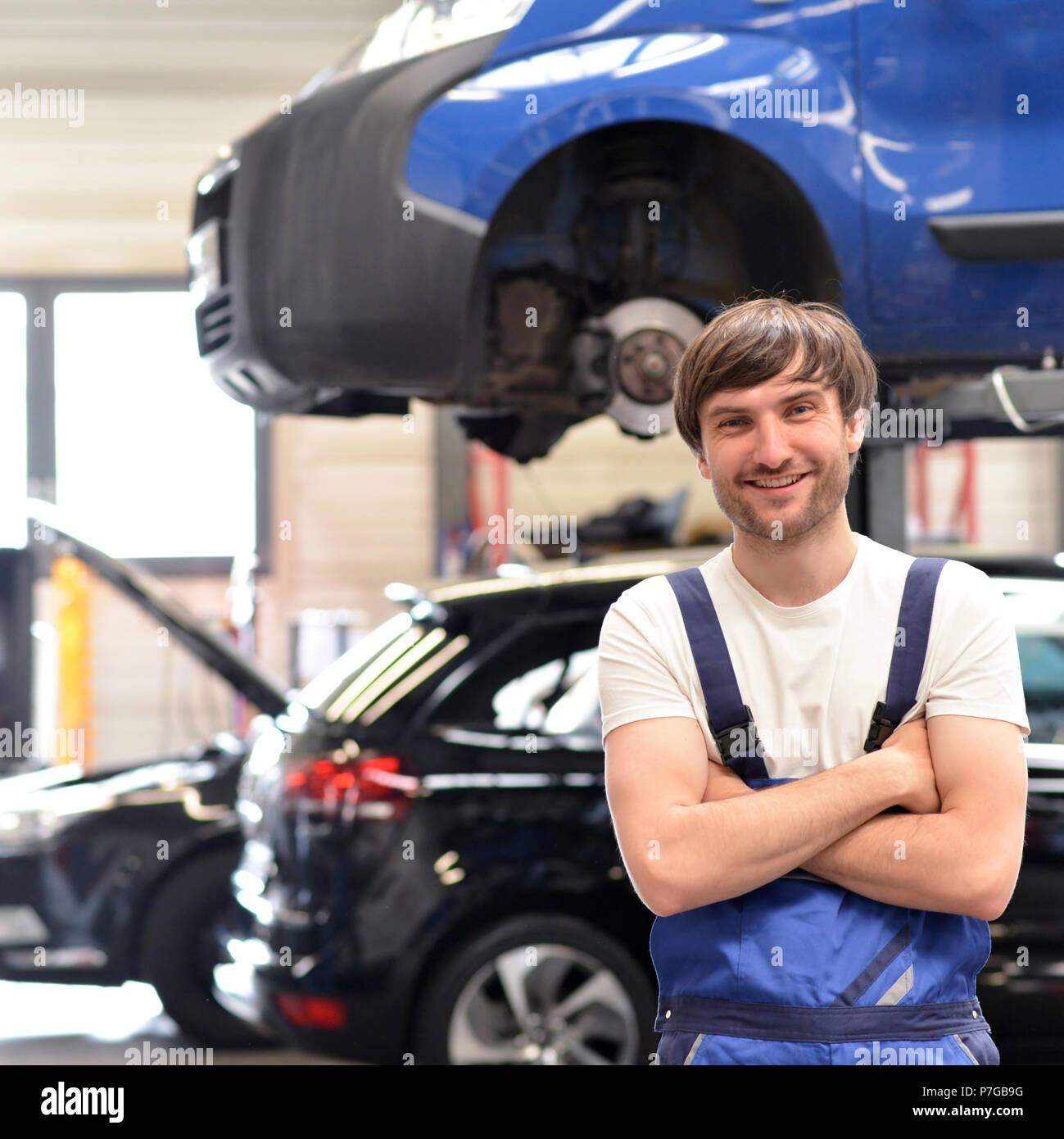 portrait smiling car mechanic in a workshop - closeup with in the ...