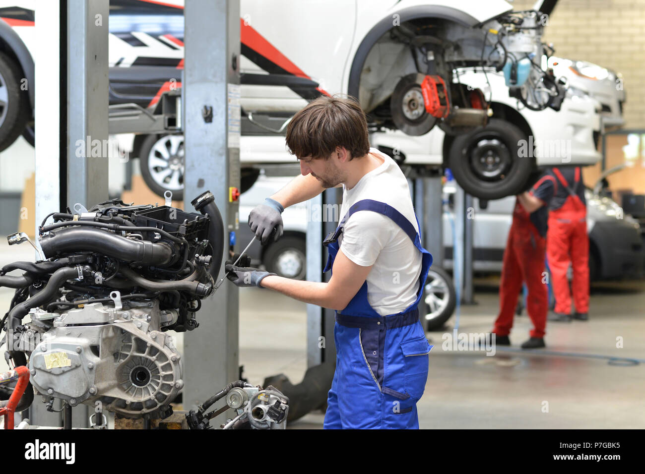 mechanic repairs engine from an automobile in the garage Stock Photo ...