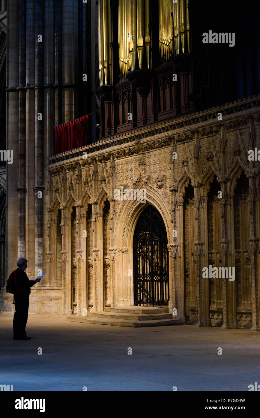Visitor in front of the stone rood screen at the medieval cathedral ...