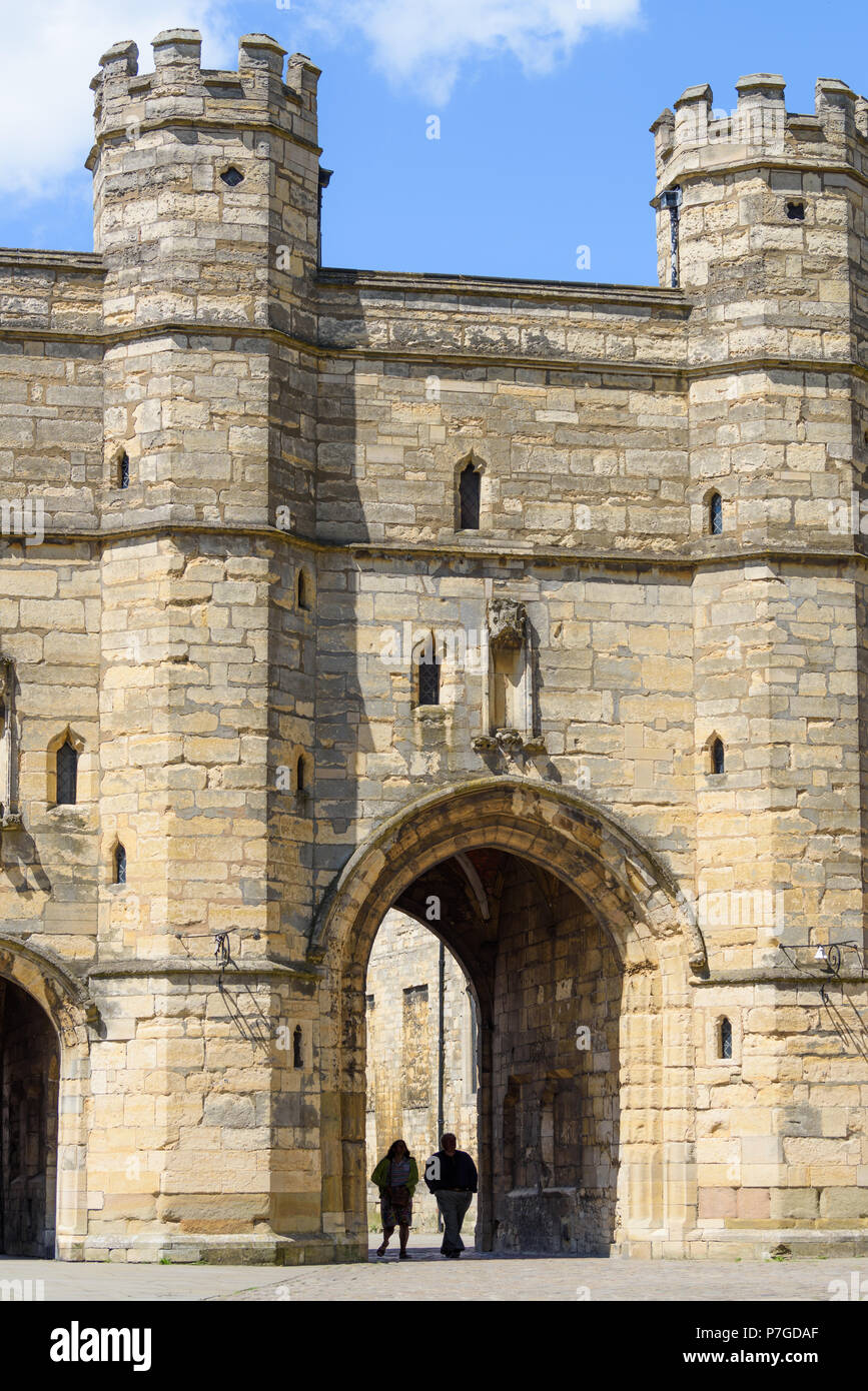 A man and woman walk through the archway of the Exchequer Gate into the ...