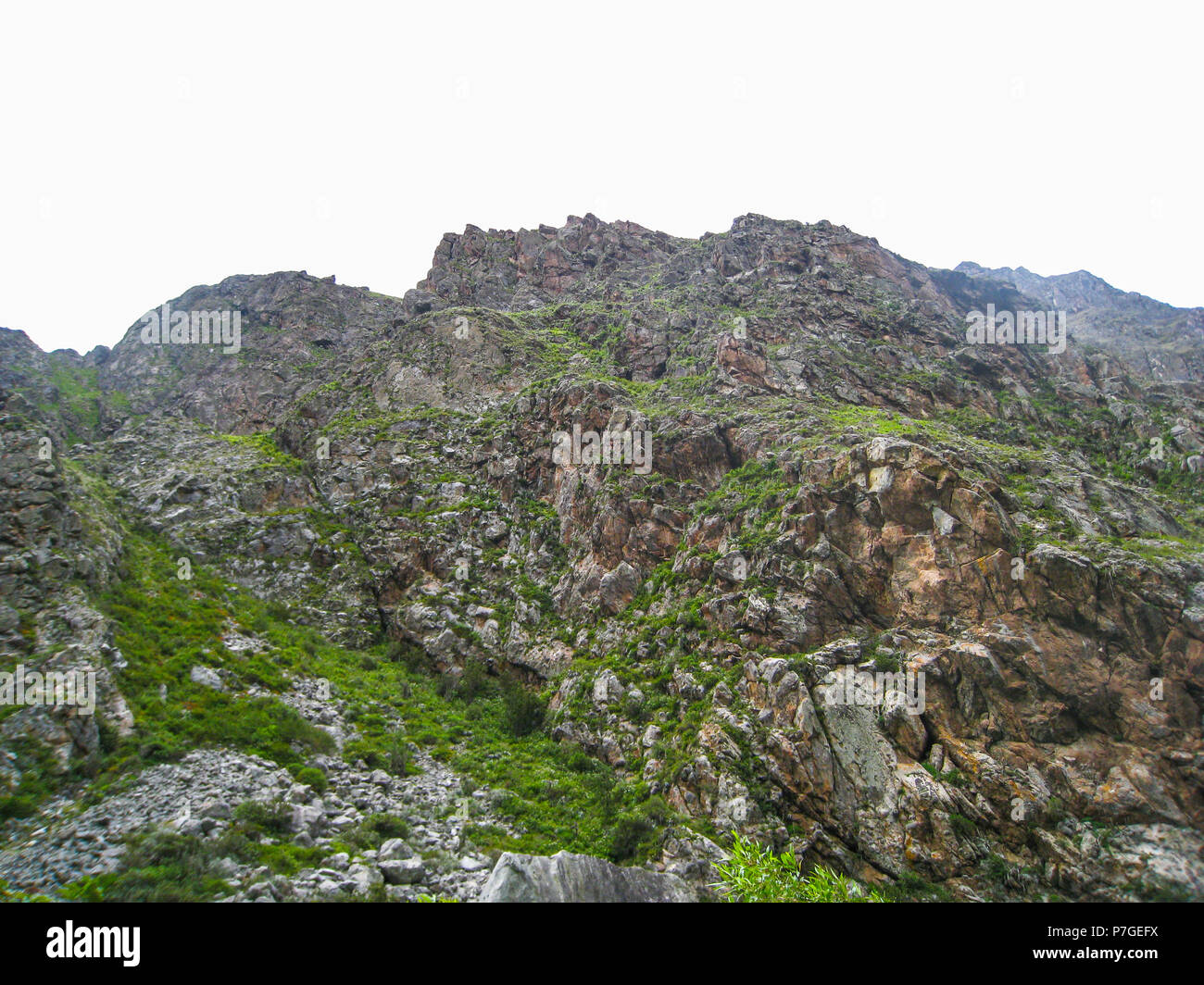 Mountain rocks covered by green grass landscape image. White clouds on ...