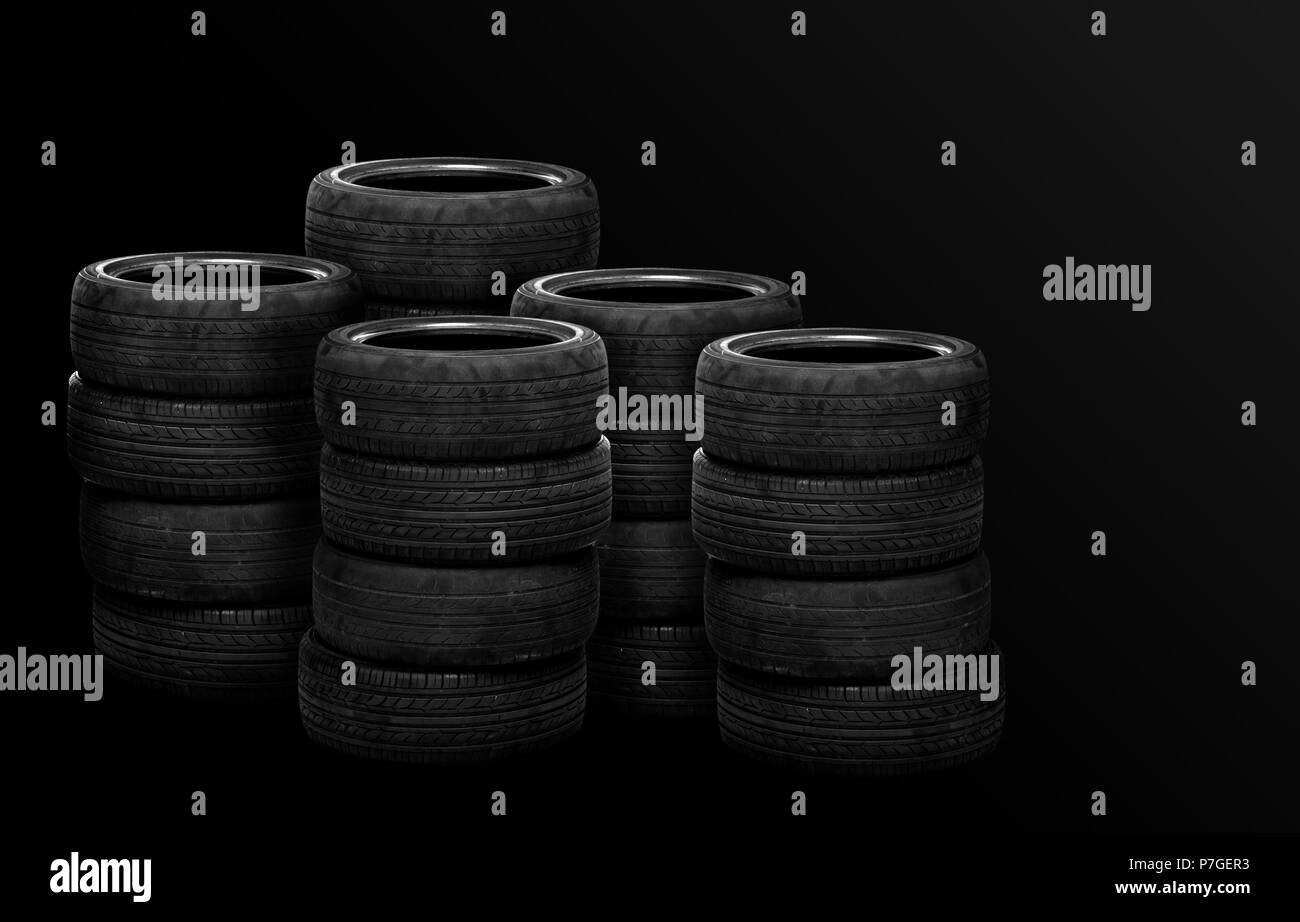 Old tires stacked, isolated on black background Stock Photo - Alamy