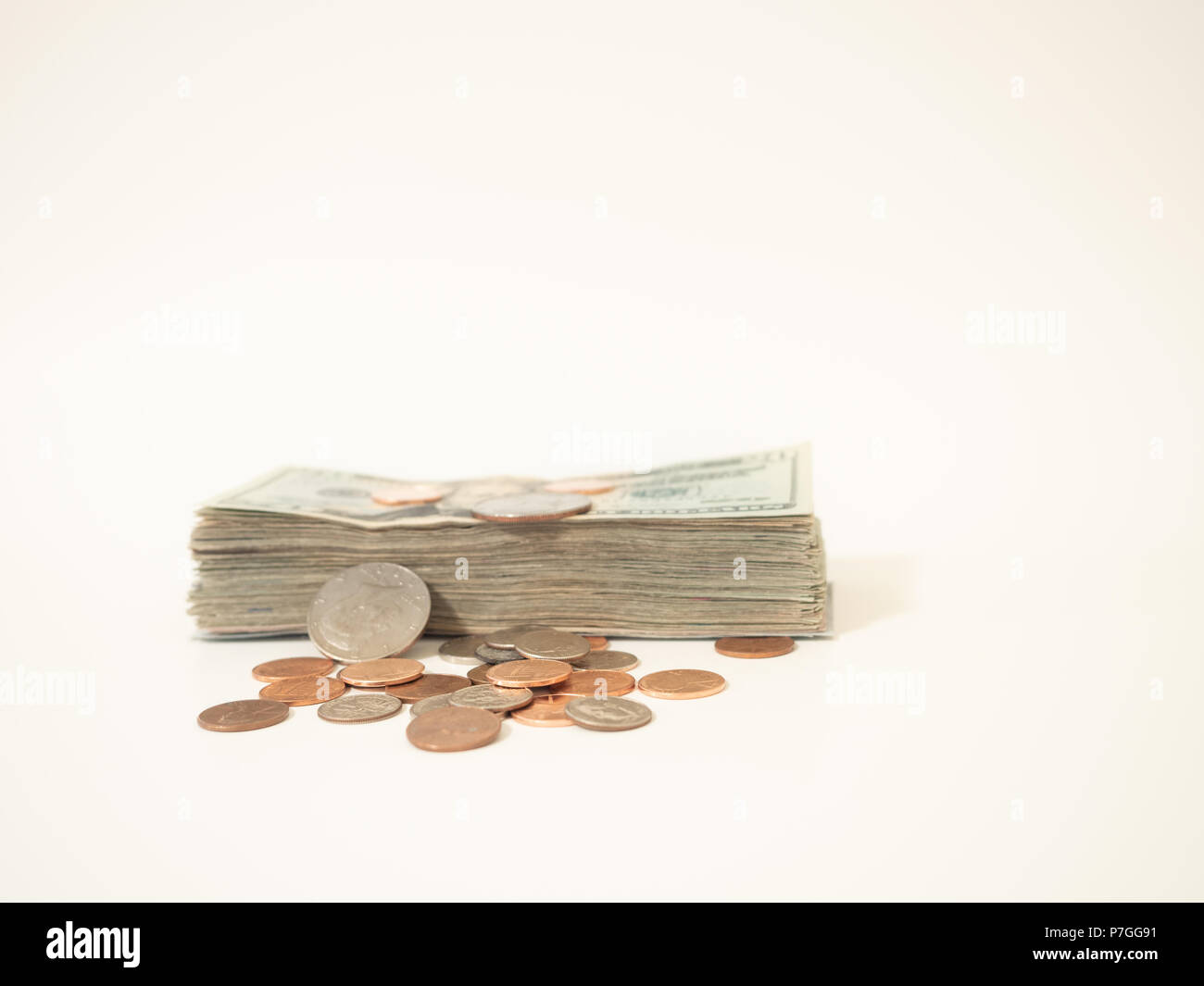 A large stack of twenty dollar bills with loose coins. The US currency ...