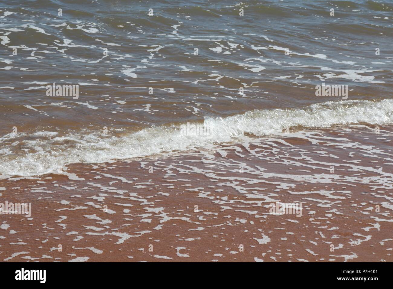 Waves arriving on beach Stock Photo - Alamy