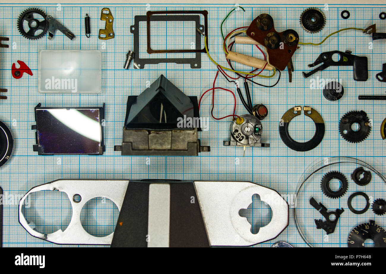 parts are completely disassembled old retro film SLR camera on graph ...