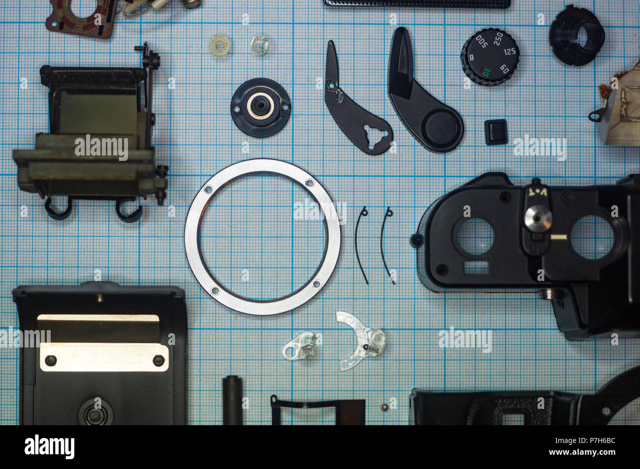 parts are completely disassembled old retro film SLR camera on graph ...