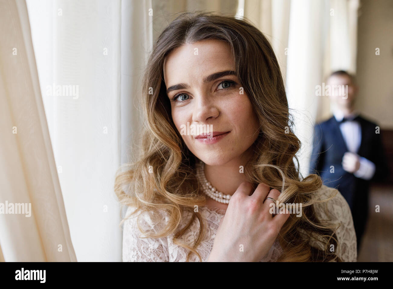 Wedding couple indoors is hugging each other. Beautiful bride in white ...