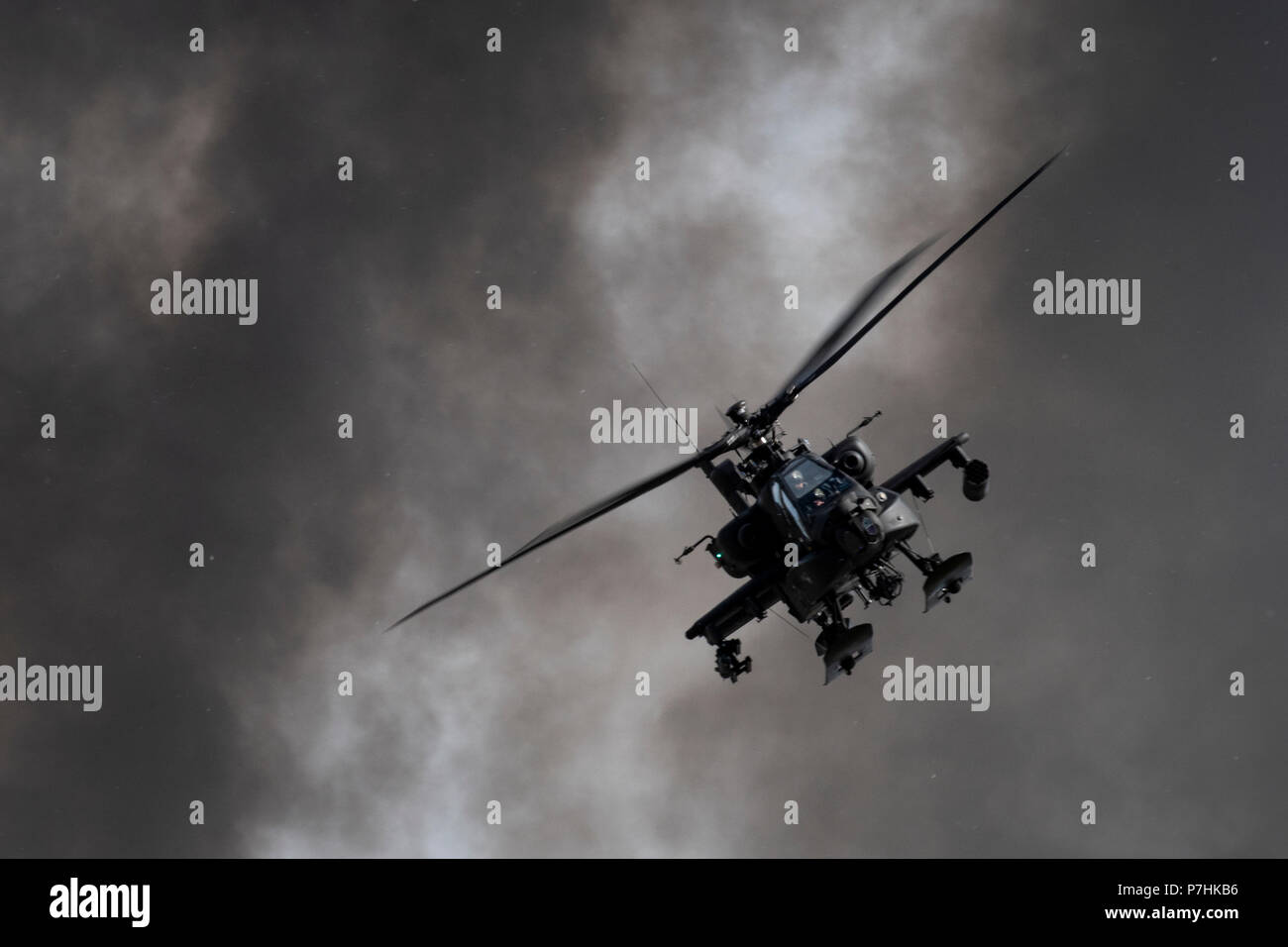 A U.S. Army AH-64 Apache attack helicopter flies through smoke from an ...