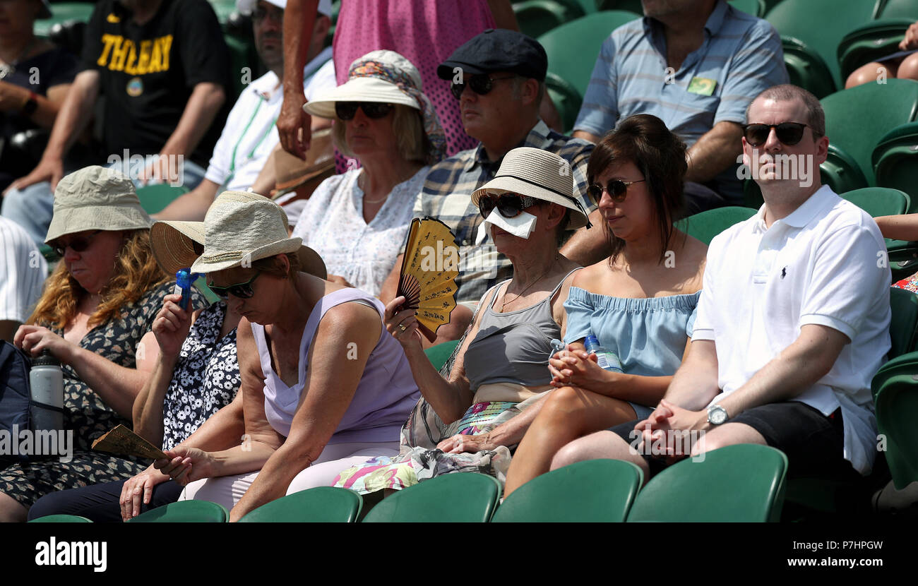Spectators shield themselves from the sun on court 2 on day five of the ...
