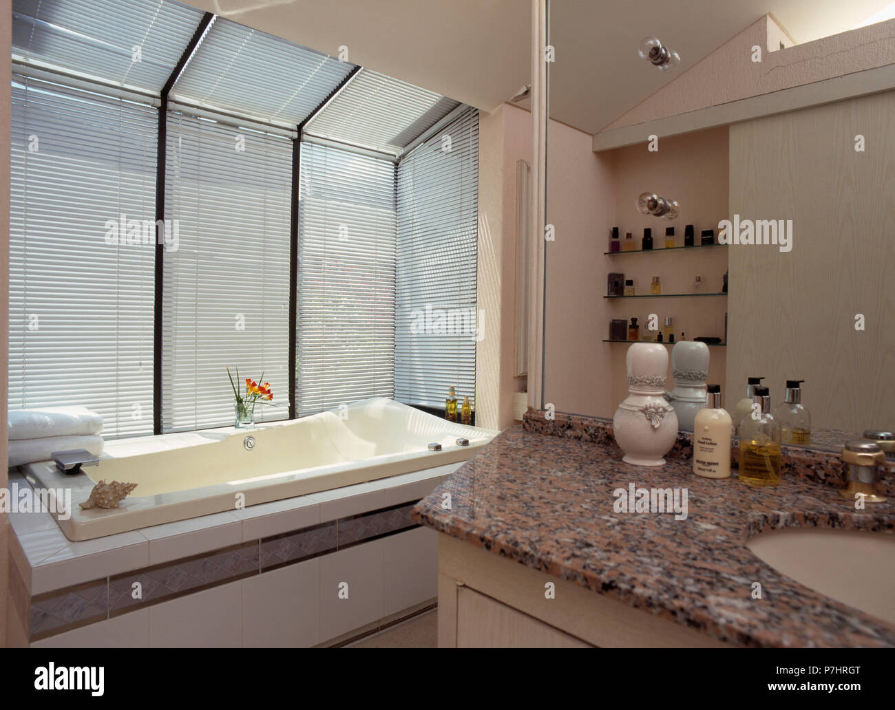 Venetian blinds on windows above bath in modern coastal bathroom with ...