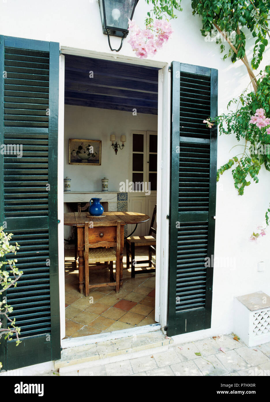 Black louvre shutters on French windows with view of dining room in ...