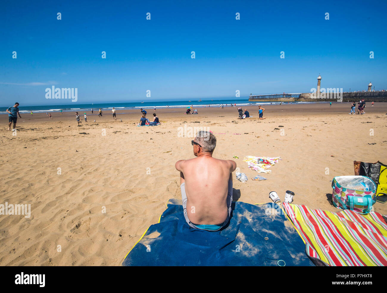 A man sunbathes on Whitby beach, North Yorkshire, as the warm weather ...