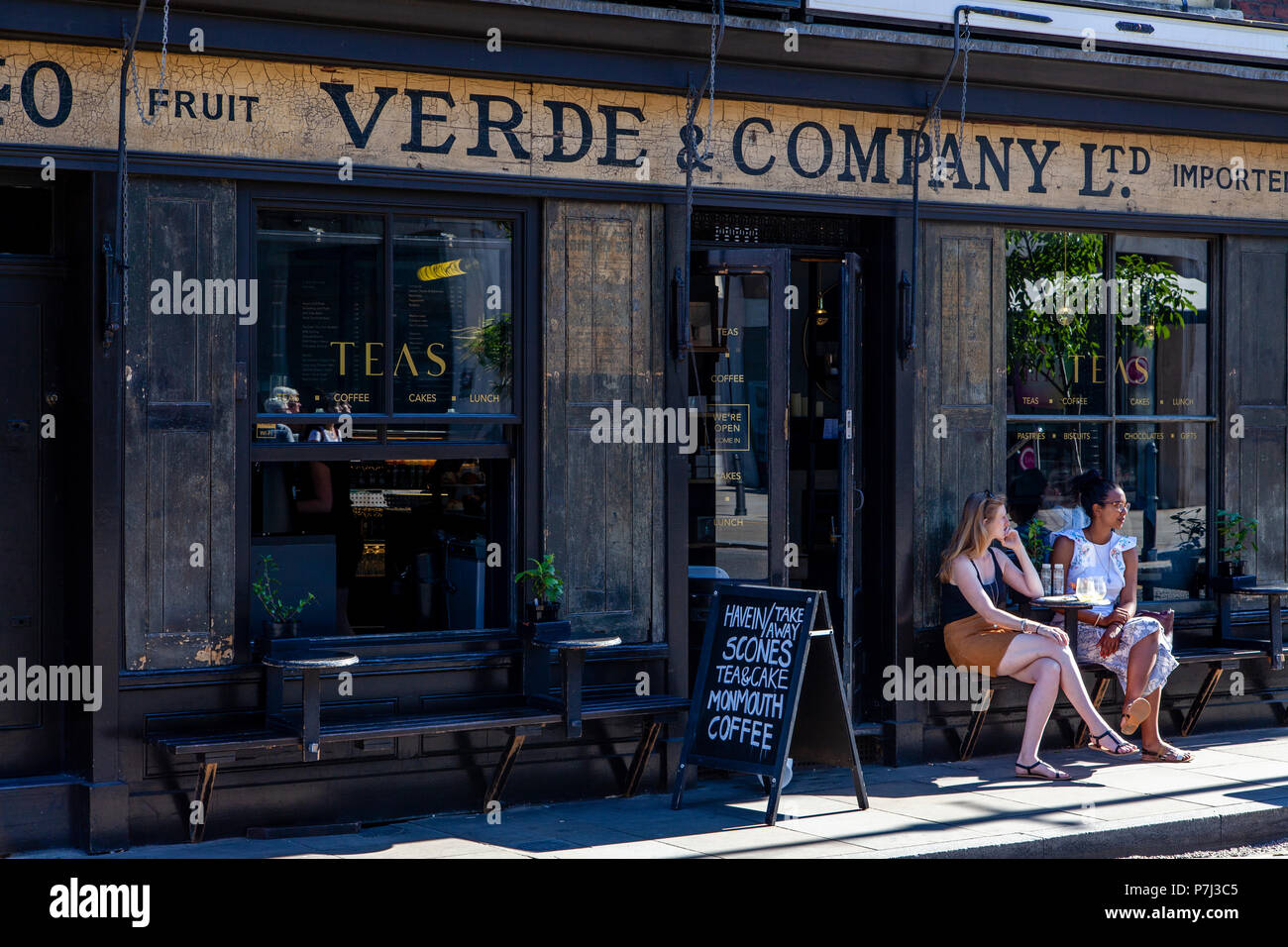 Two Young Women Sitting Outside Verde & Company Cafe, Spitalfields ...