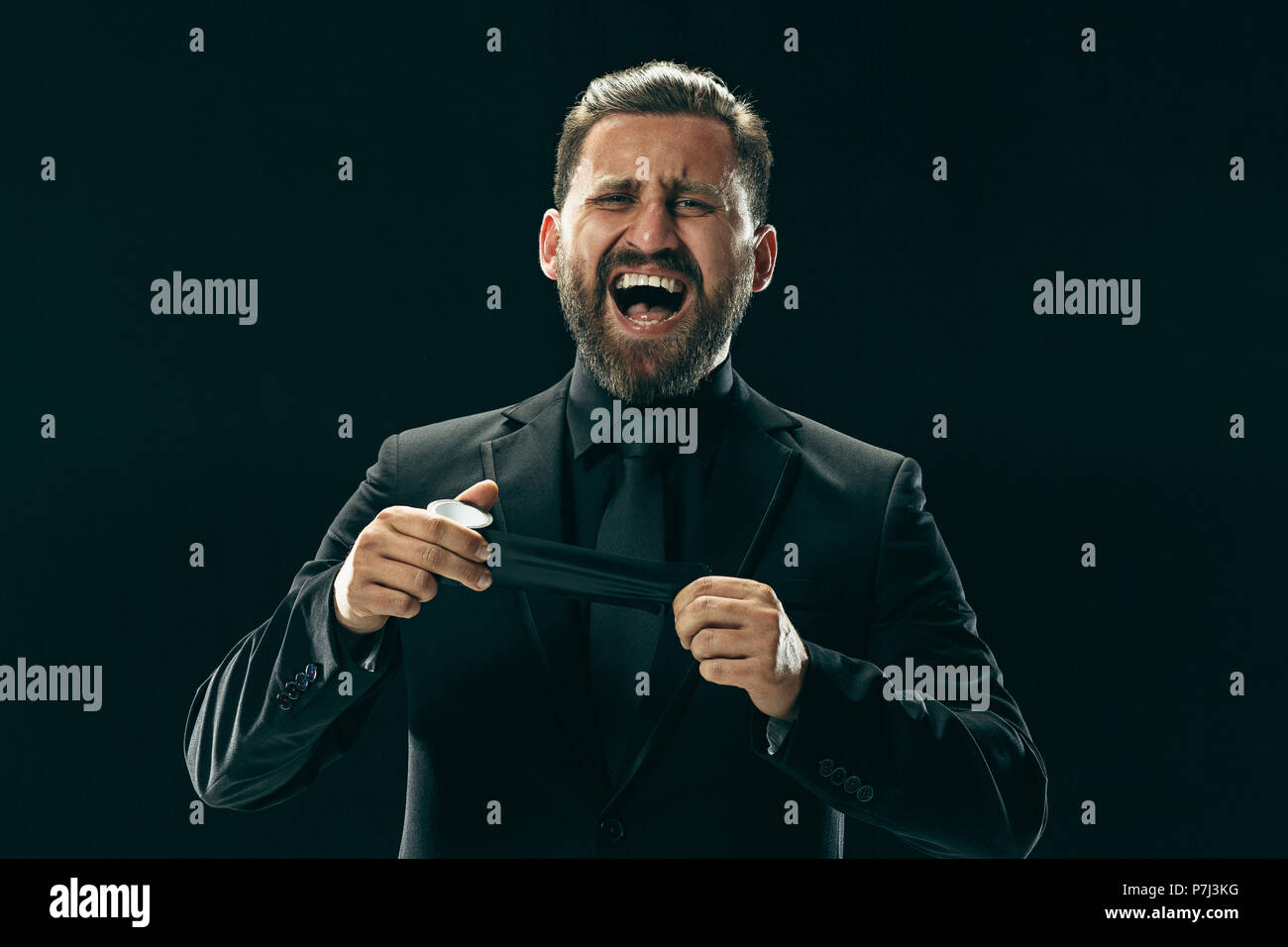 The barded man in a suit at black studio Stock Photo - Alamy