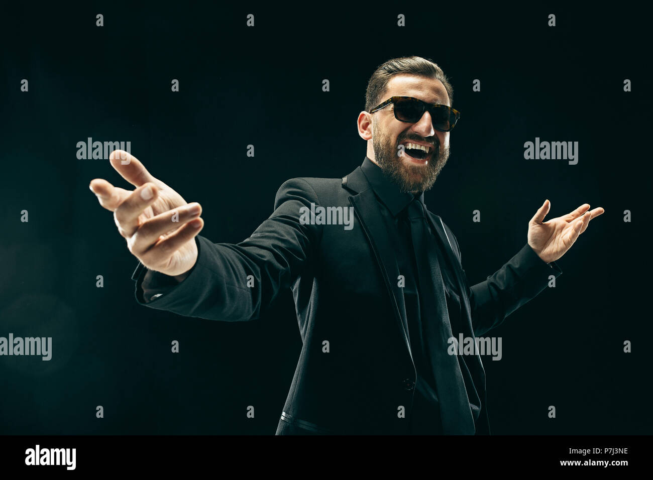 The barded man in a suit at black studio Stock Photo - Alamy