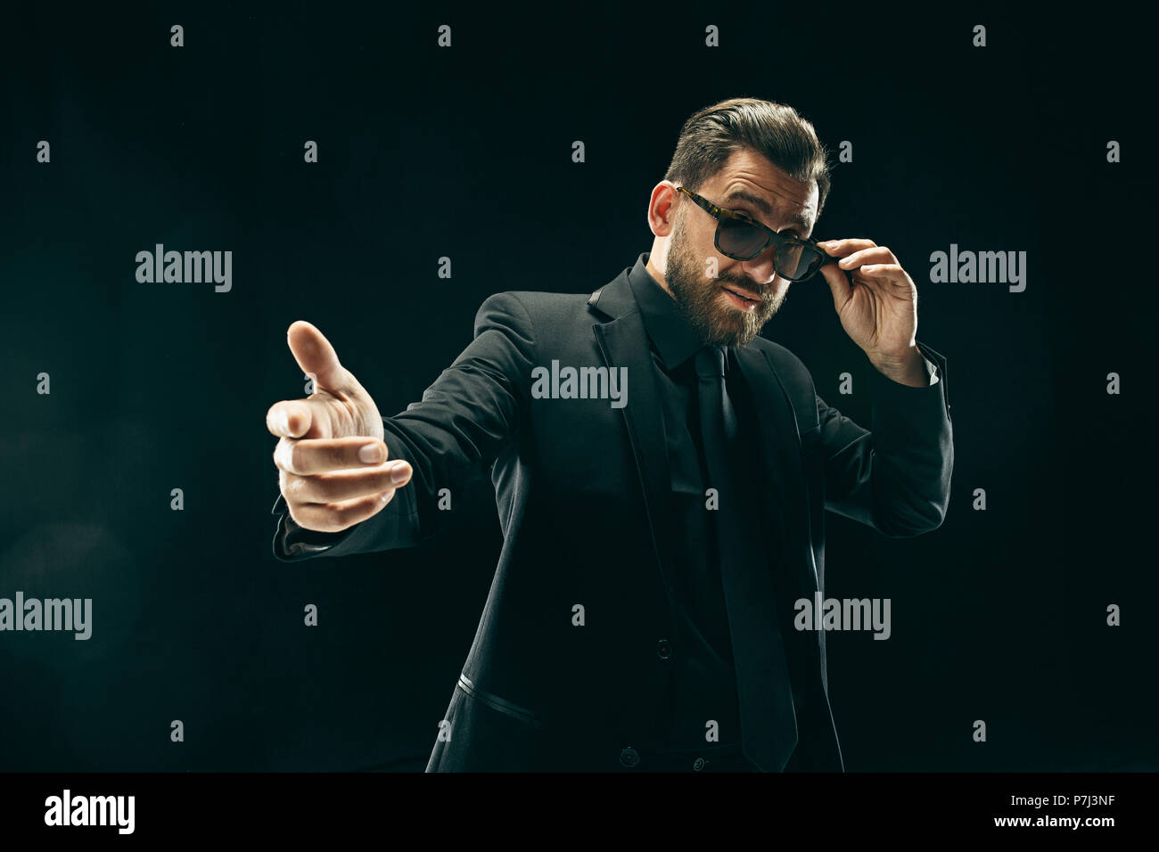 The barded man in a suit at black studio Stock Photo - Alamy