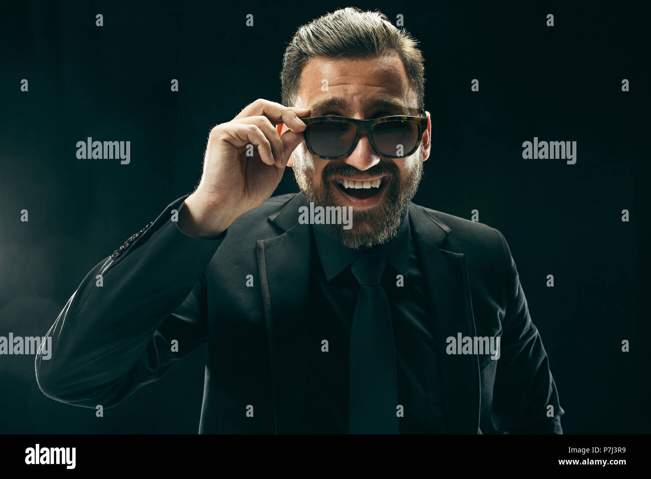 The barded man in a suit at black studio Stock Photo - Alamy