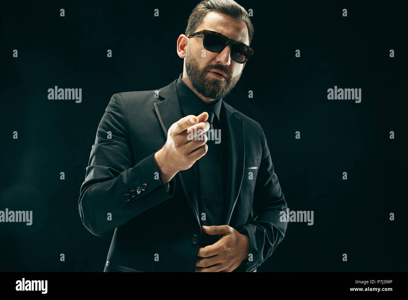 The barded man in a suit at black studio Stock Photo - Alamy