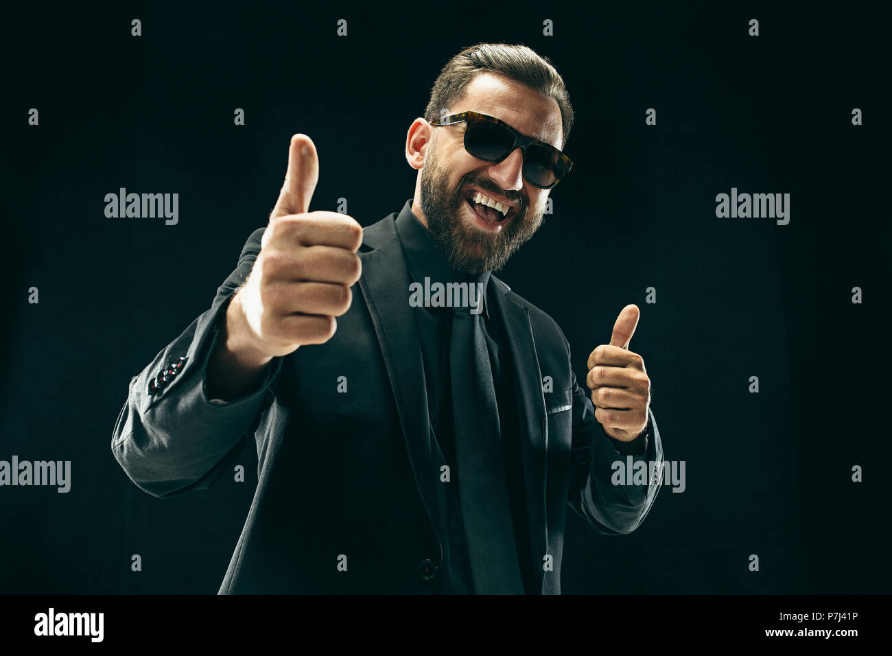 The barded man in a suit at black studio Stock Photo - Alamy