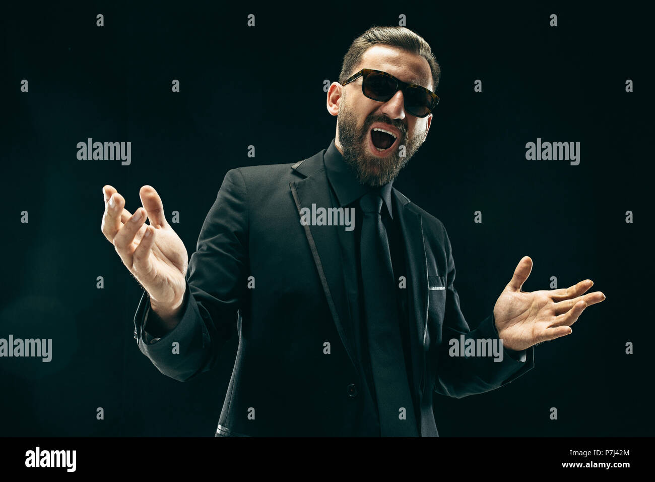 The barded man in a suit at black studio Stock Photo - Alamy