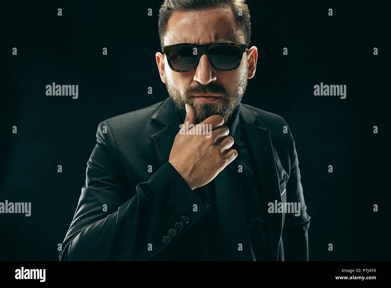 The barded man in a suit at black studio Stock Photo - Alamy