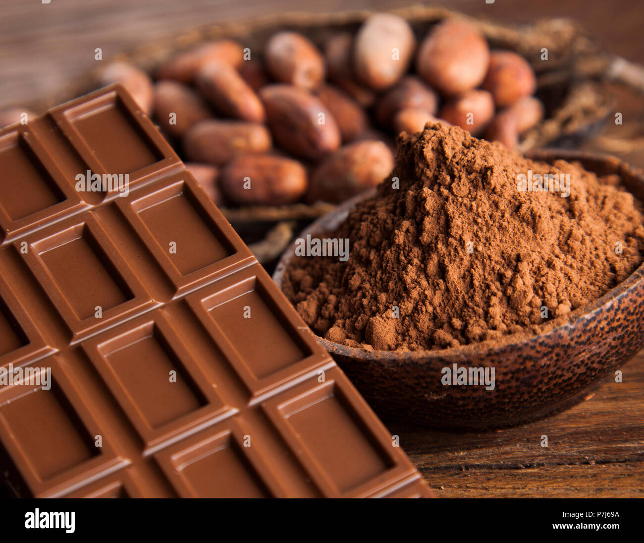 Chocolate bar, candy sweet, cacao beans and powder on wooden background ...