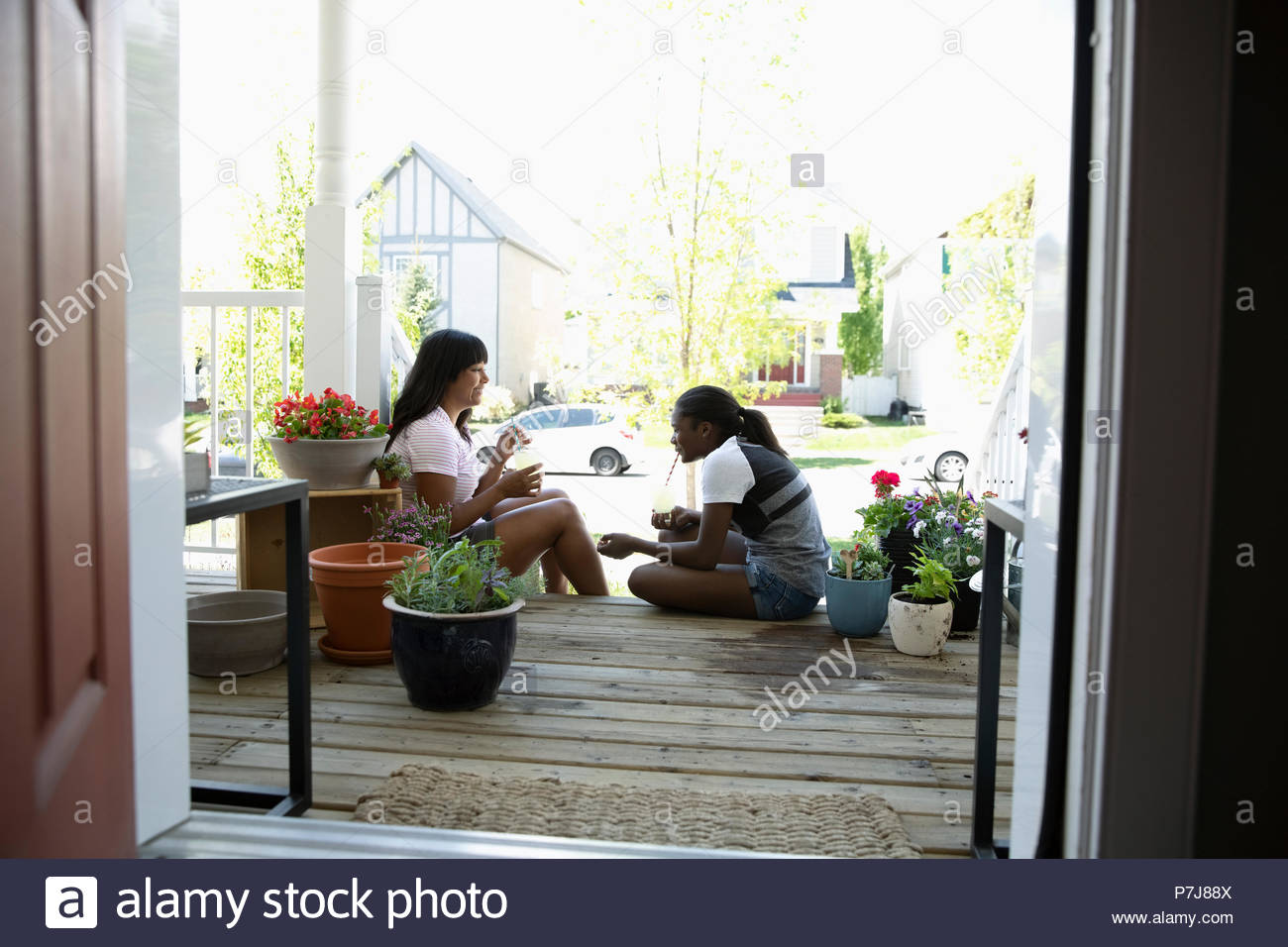 Mother and daughter bonding, talking and planting flowers on front ...