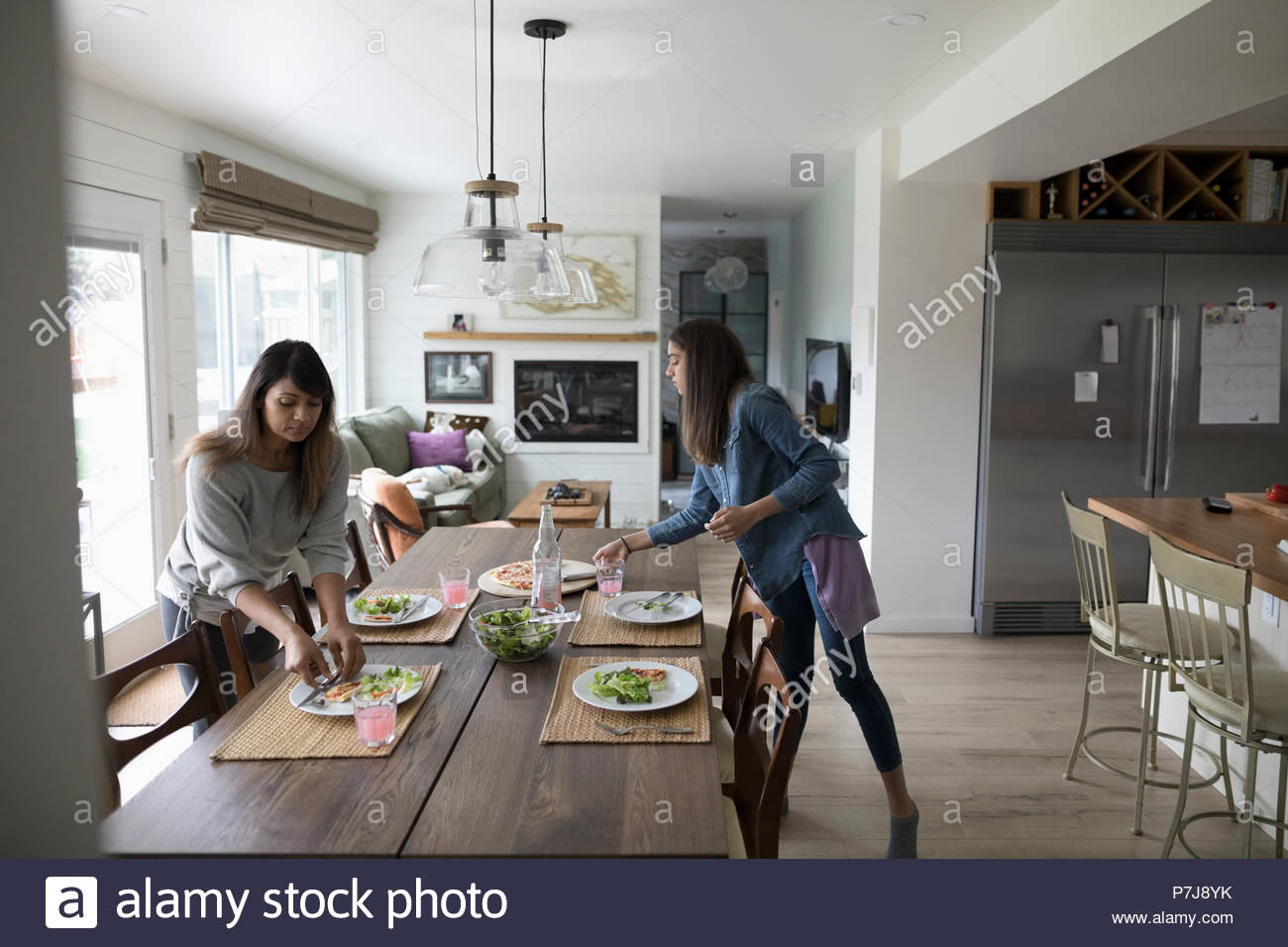 Mother and tween daughter setting the table Stock Photo - Alamy