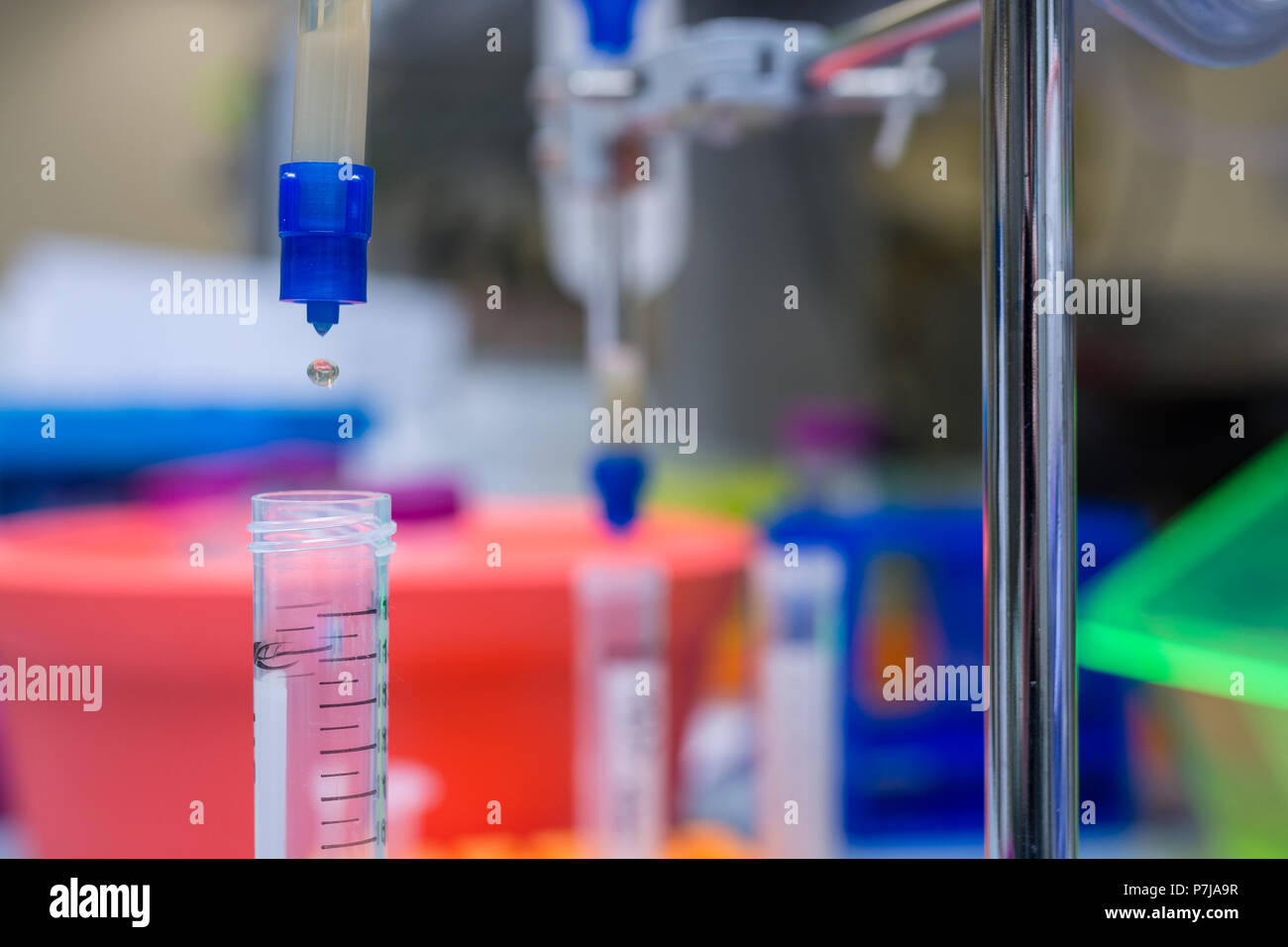 Liquid dripping through a filter column with a drop in mid air ...