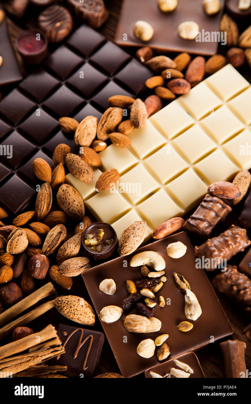 Chocolate bars and pralines on wooden background Stock Photo - Alamy