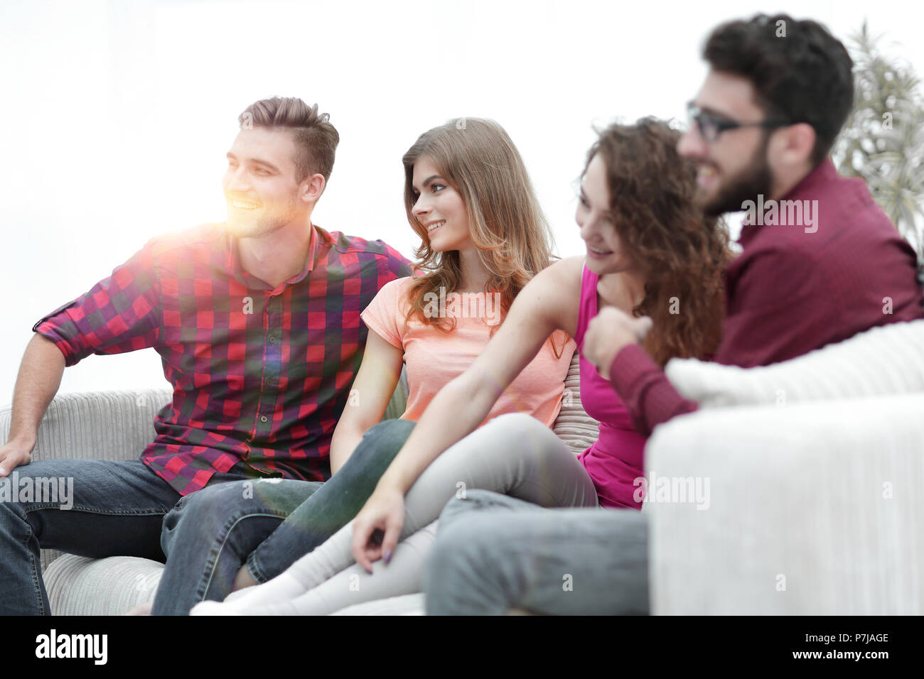 group of cheerful friends sitting on the couch Stock Photo - Alamy