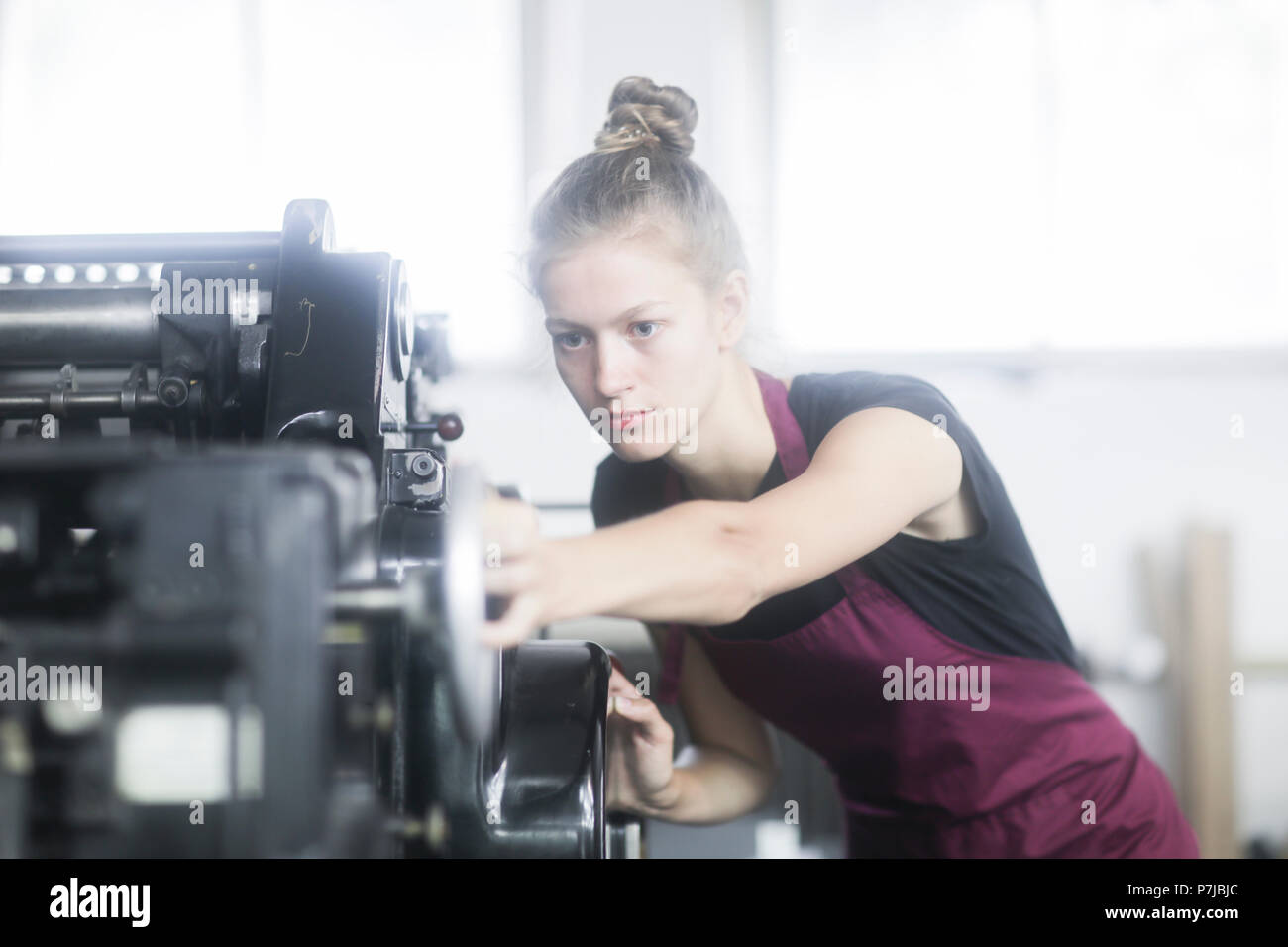 Woman operating a printing press in a factory Stock Photo - Alamy