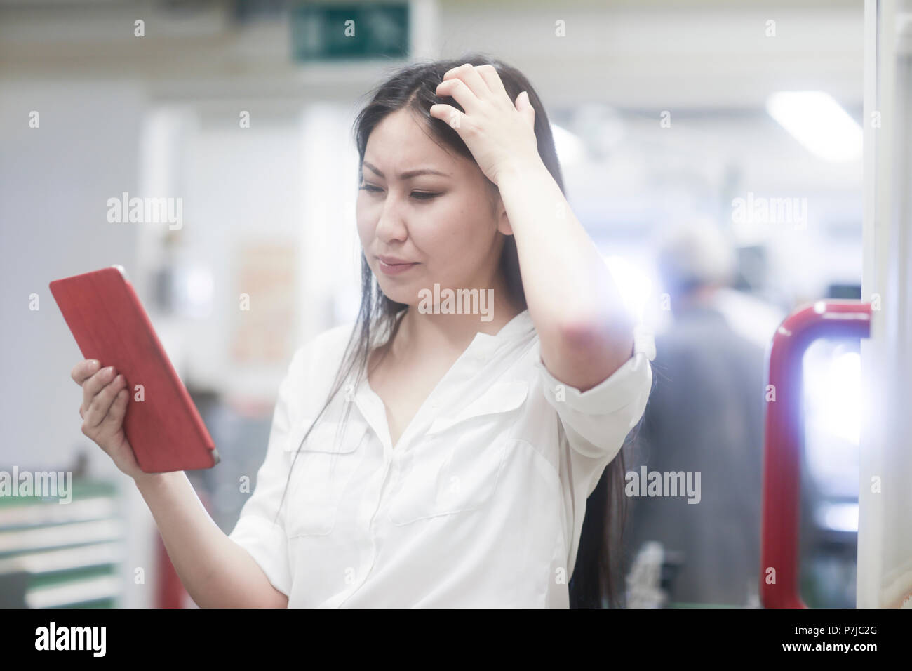 Female engineer looking at technical drawings on a digital tablet ...