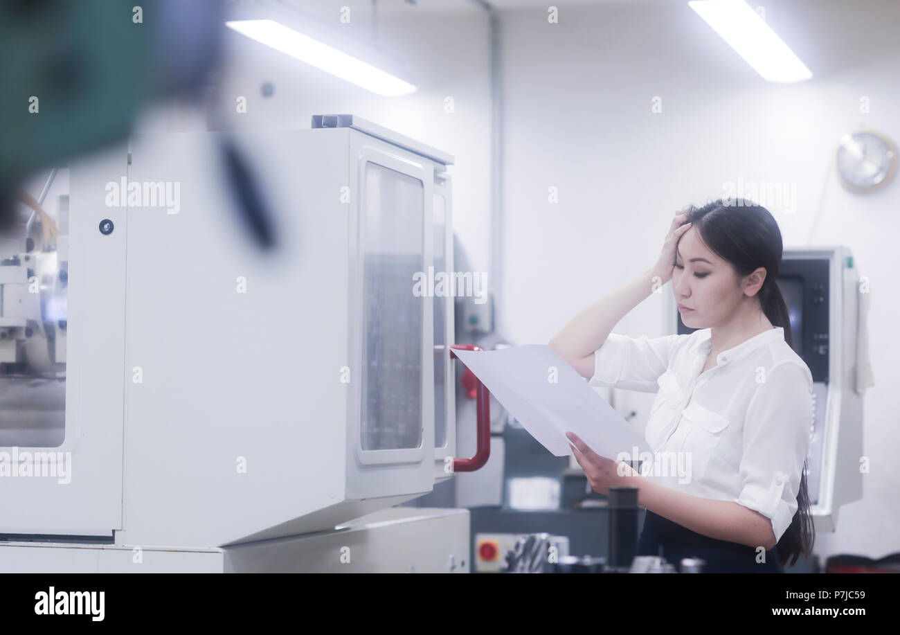 Confused Female engineer looking at a technical drawing Stock Photo - Alamy