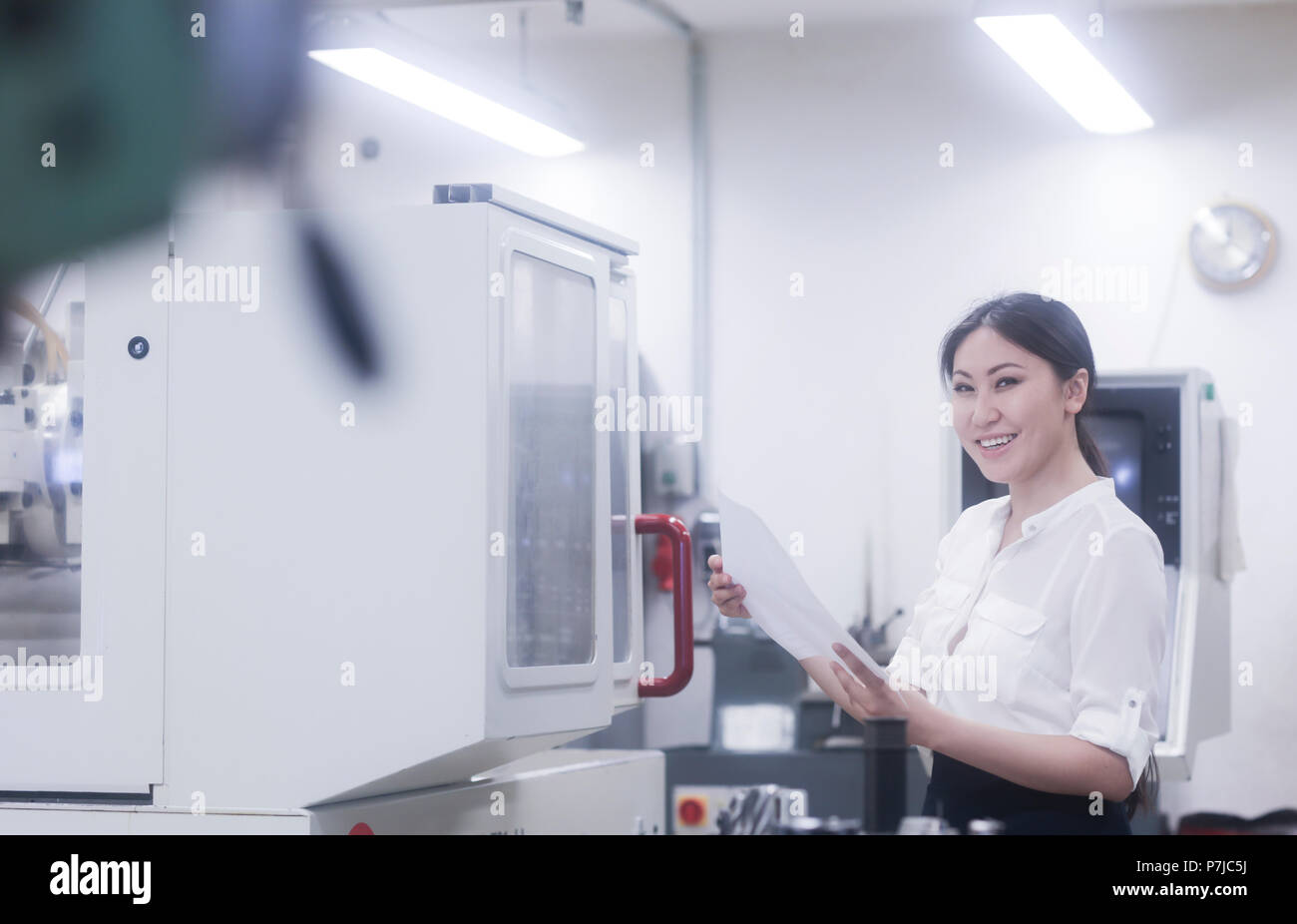 Smiling female engineer looking at a technical drawing Stock Photo - Alamy