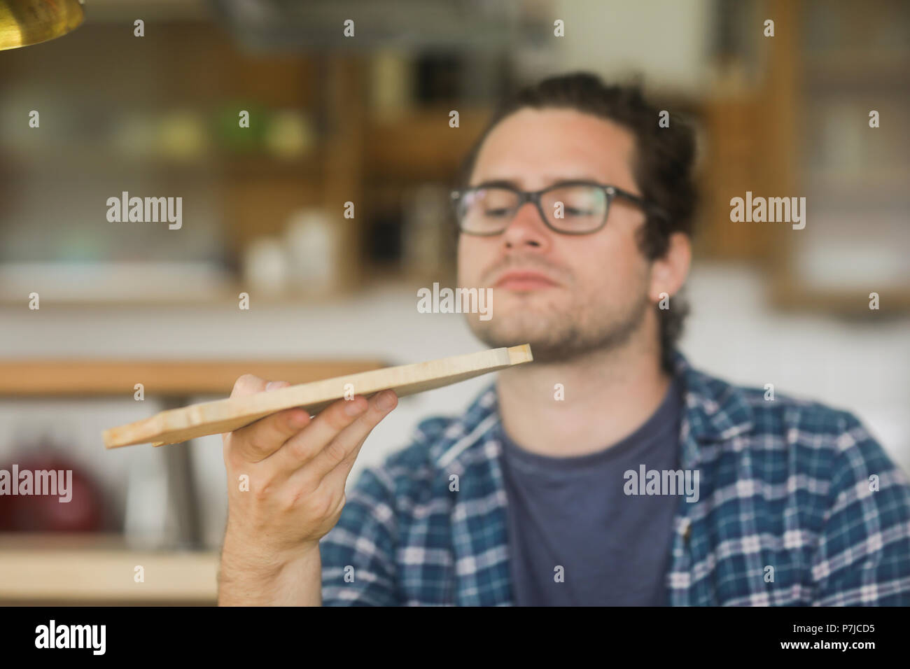 Man standing in kitchen holding a homemade chopping board Stock Photo ...