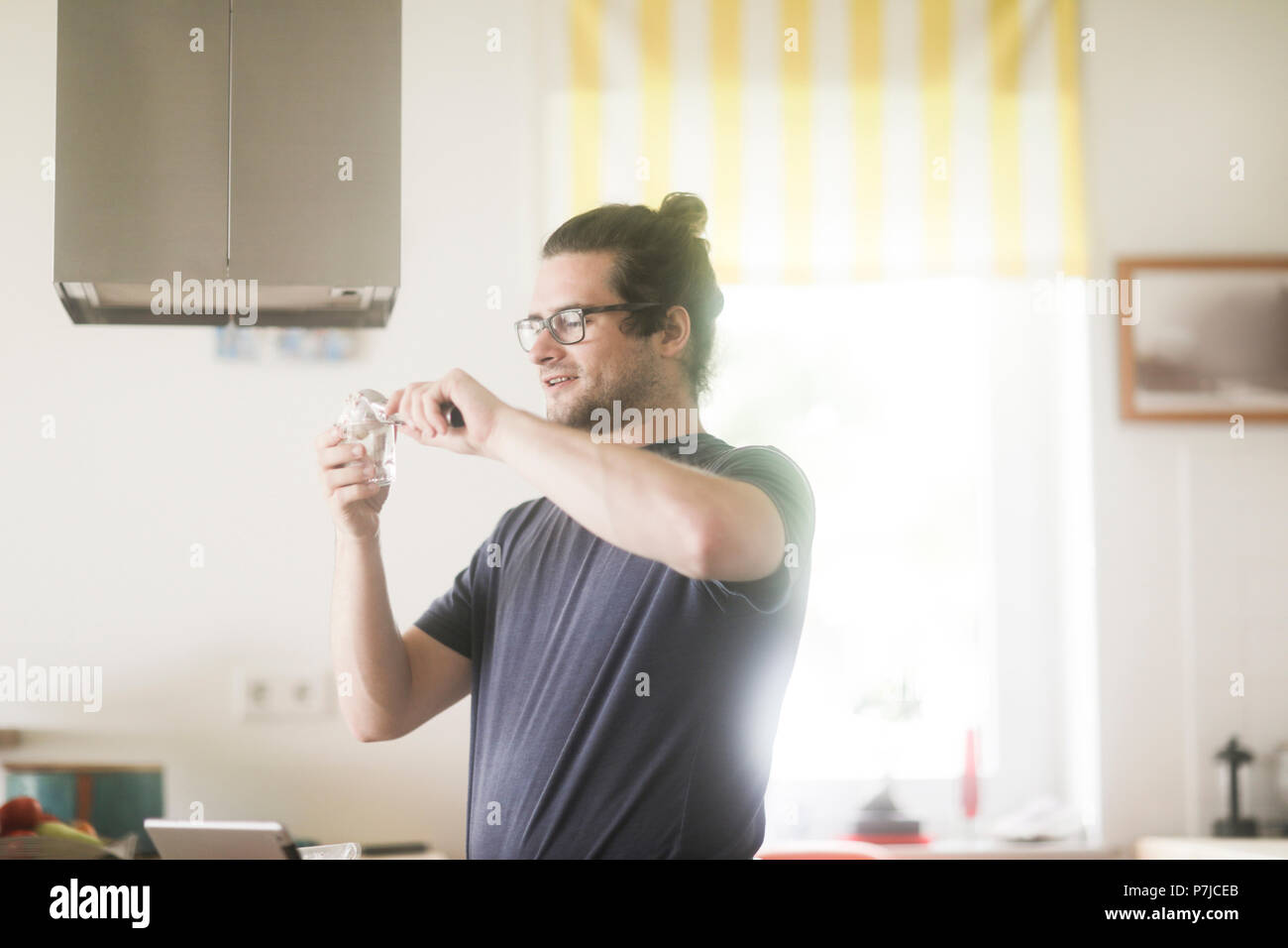Man standing in kitchen preparing ice-cream sundae dessert Stock Photo ...