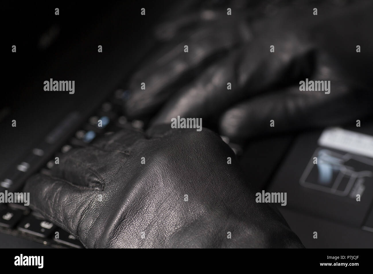 Hacker hand in glove working on laptop.Concept of internet criminal ...