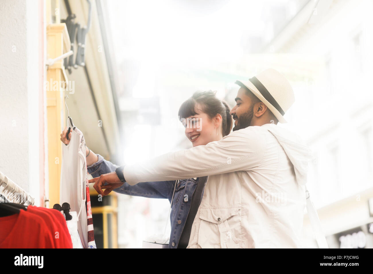 Couple standing outside a store looking at clothes Stock Photo - Alamy