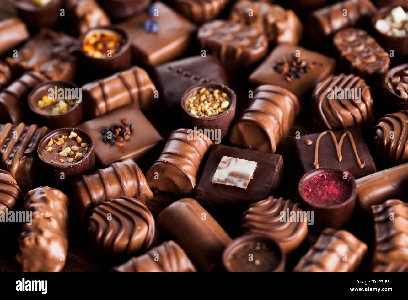 Chocolate bars and pralines on wooden background Stock Photo - Alamy