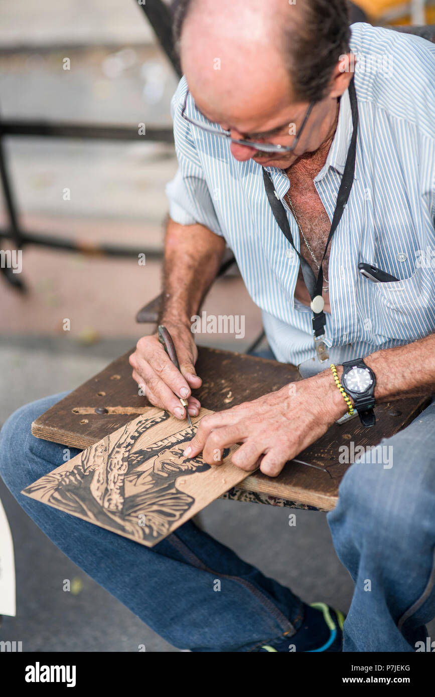 A Cuban artist works on his prints at an outdoor market in Havana Stock ...