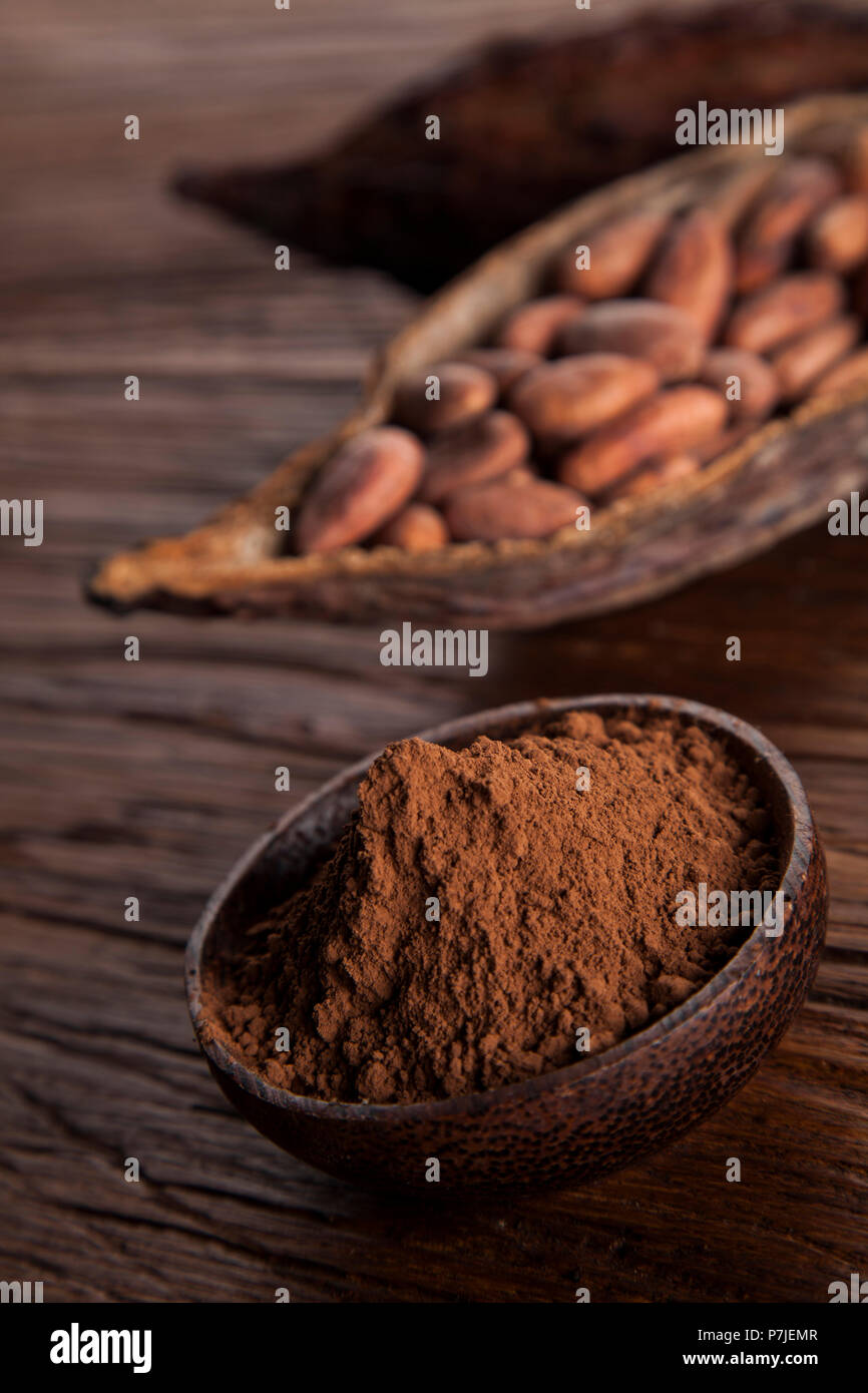 Cocoa beans in the dry cocoa pod fruit on wooden background Stock Photo ...