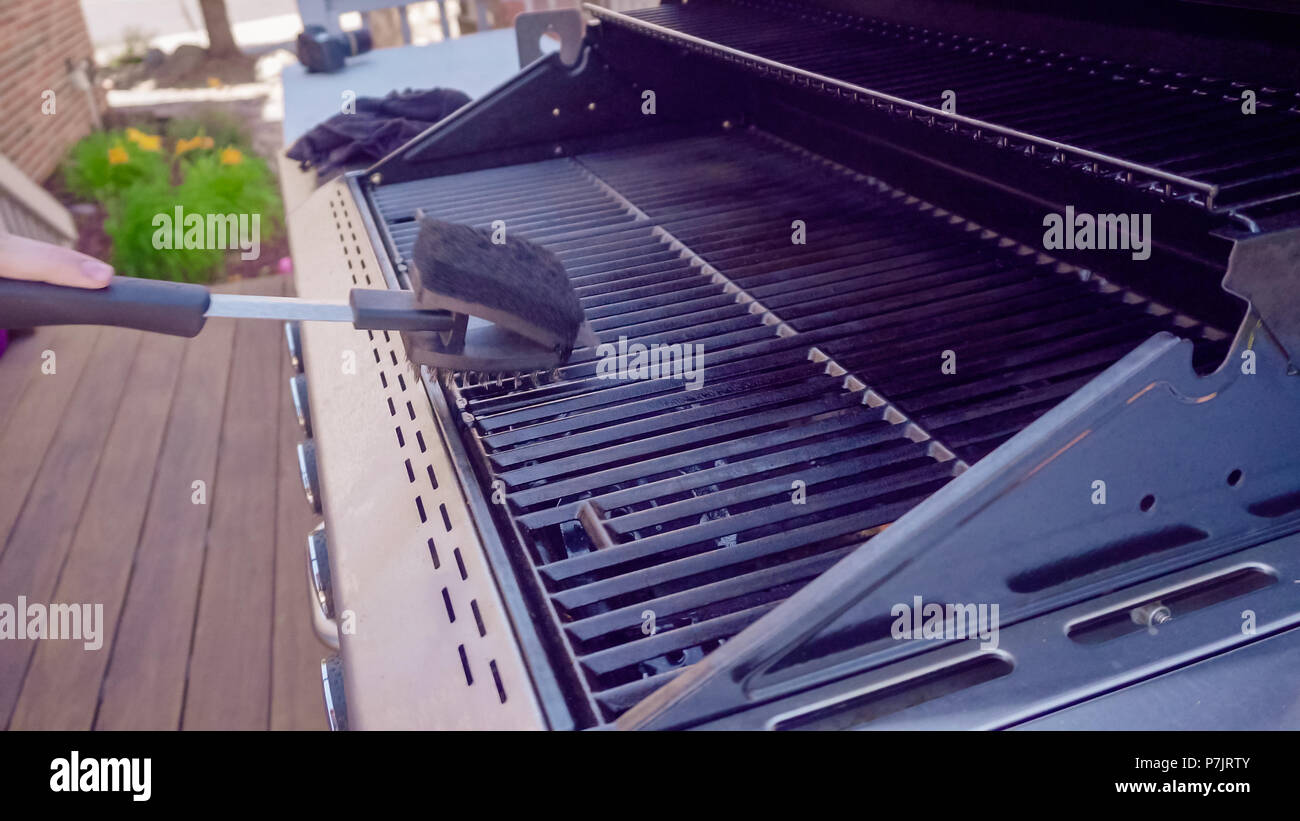 Step by step. Cleaning outdoor gas grill on back patio Stock Photo - Alamy