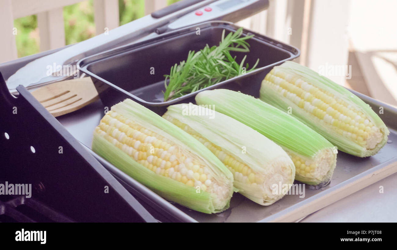 Step by step. Grilling fresh corn on outdoor gas grill Stock Photo - Alamy