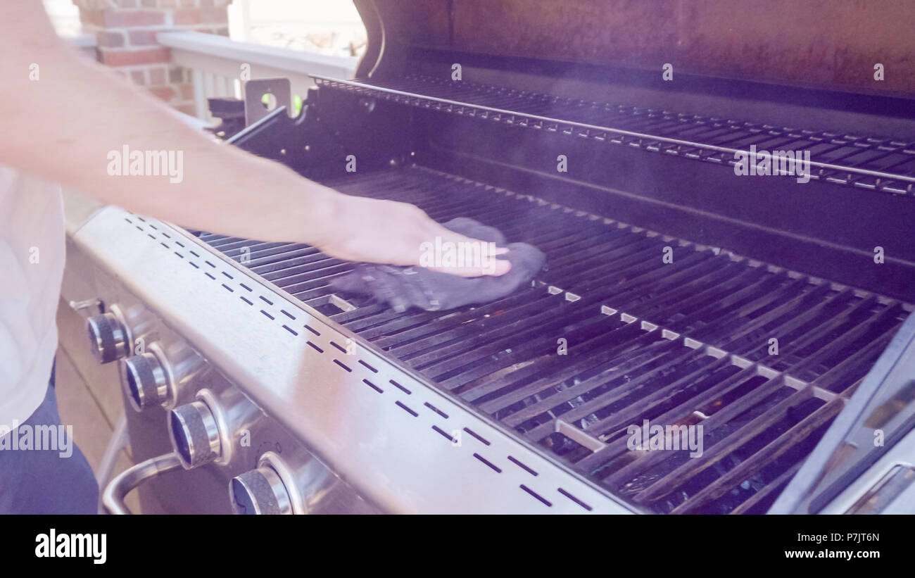 Step by step. Cleaning outdoor gas grill on back patio Stock Photo - Alamy