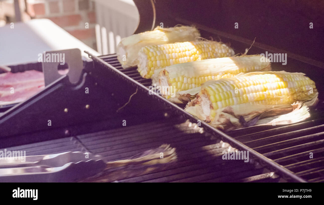 Step by step. Grilling fresh corn on outdoor gas grill Stock Photo - Alamy