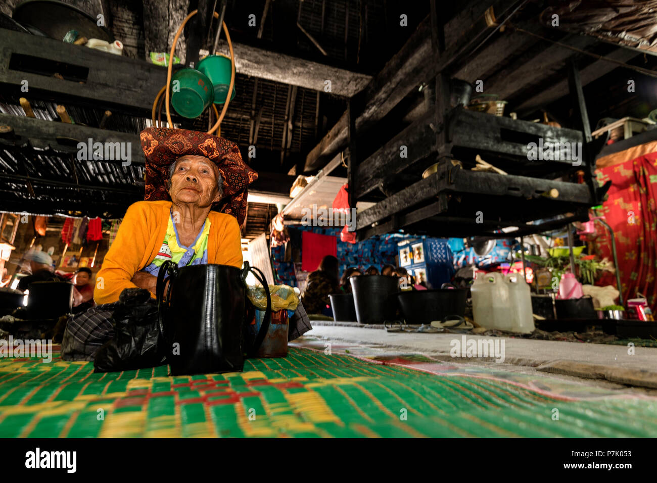 Old Batak woman sitting on the floor of her traditional house Stock ...