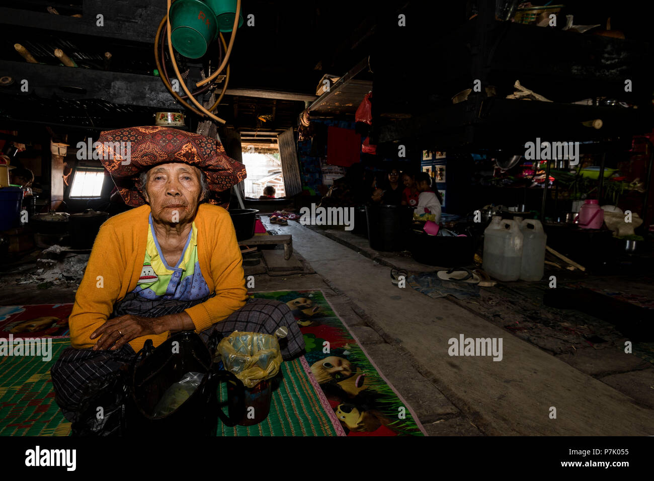 Old Batak woman sitting on the floor of her traditional house Stock ...