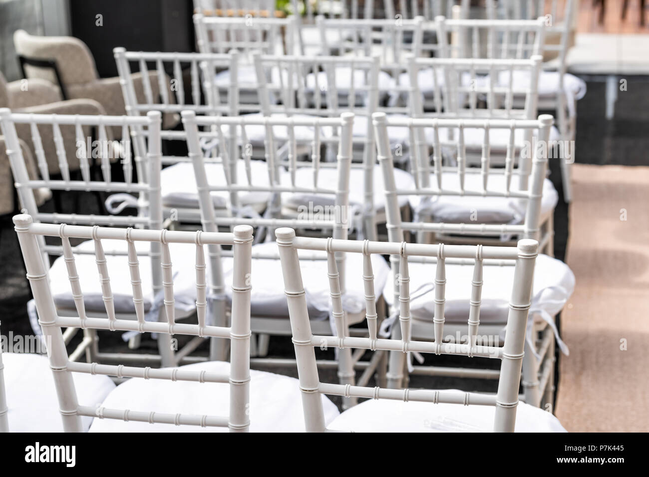 White wedding chairs closeup for ceremony with background of rows of ...
